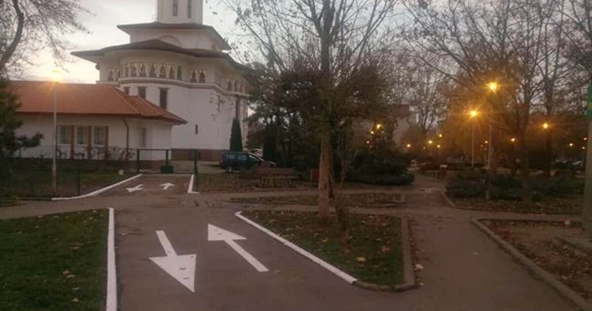 Semne de circulatie pe o alee din parc, spre o biserica din Timisoara ...